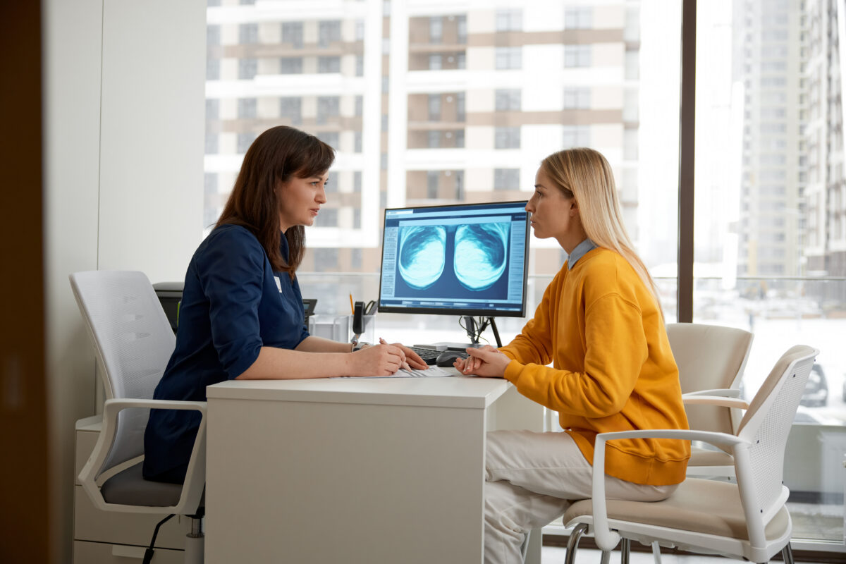 Woman doctor explaining x-ray scan to patient during medical ...